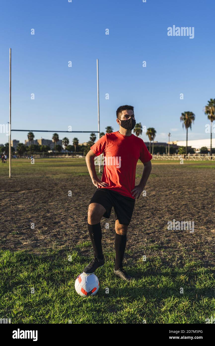 Footballer in a black mask posing with a ball Stock Photo - Alamy
