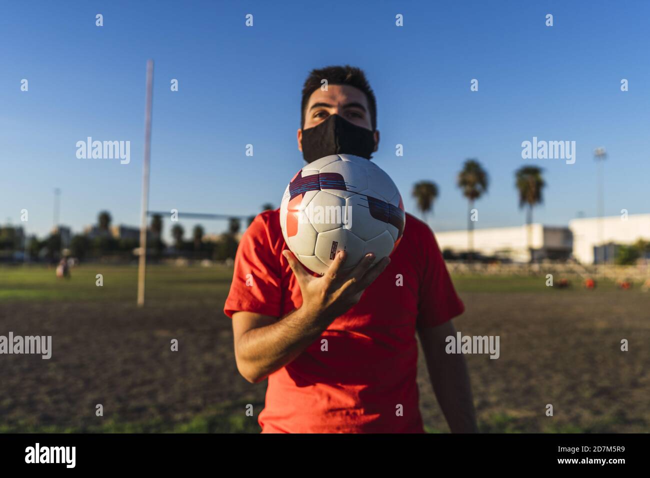 Soccer player in a black mask doing tricks with the ball Stock Photo ...