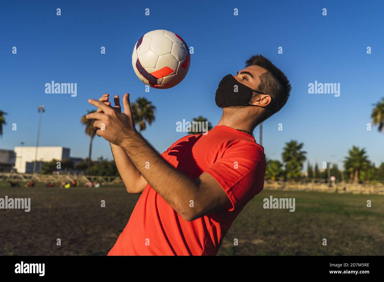 Soccer player in a black mask doing tricks with the ball Stock Photo ...