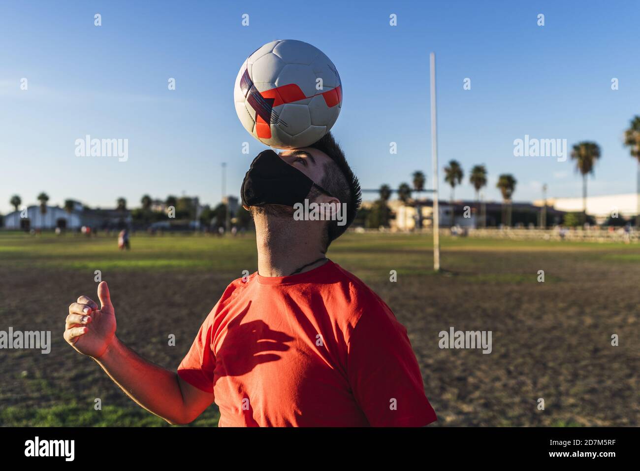 Soccer player in a black mask doing tricks with the ball Stock Photo ...