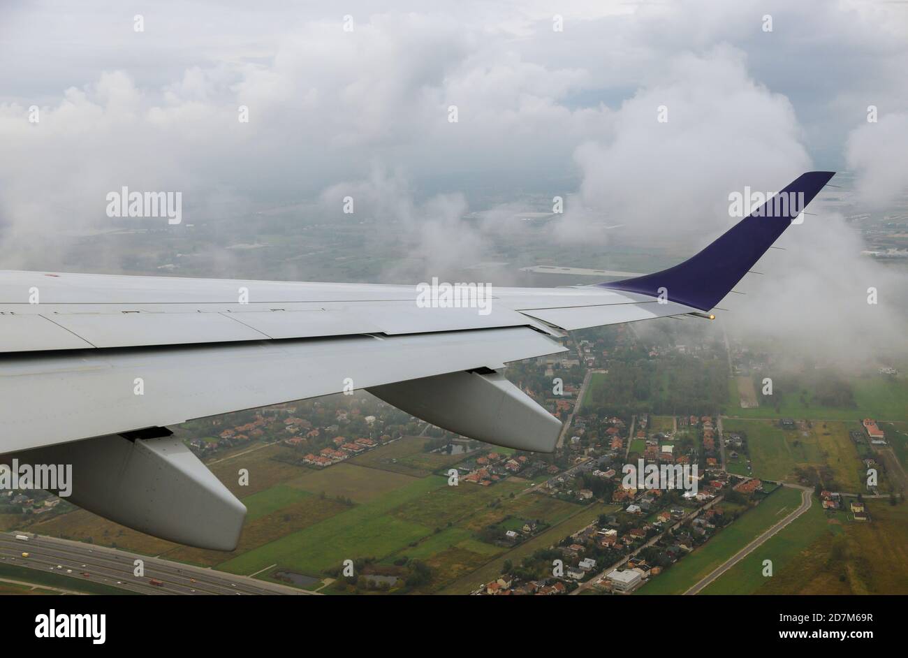 Airplane in the sky over fields the wing is visible through the window ...