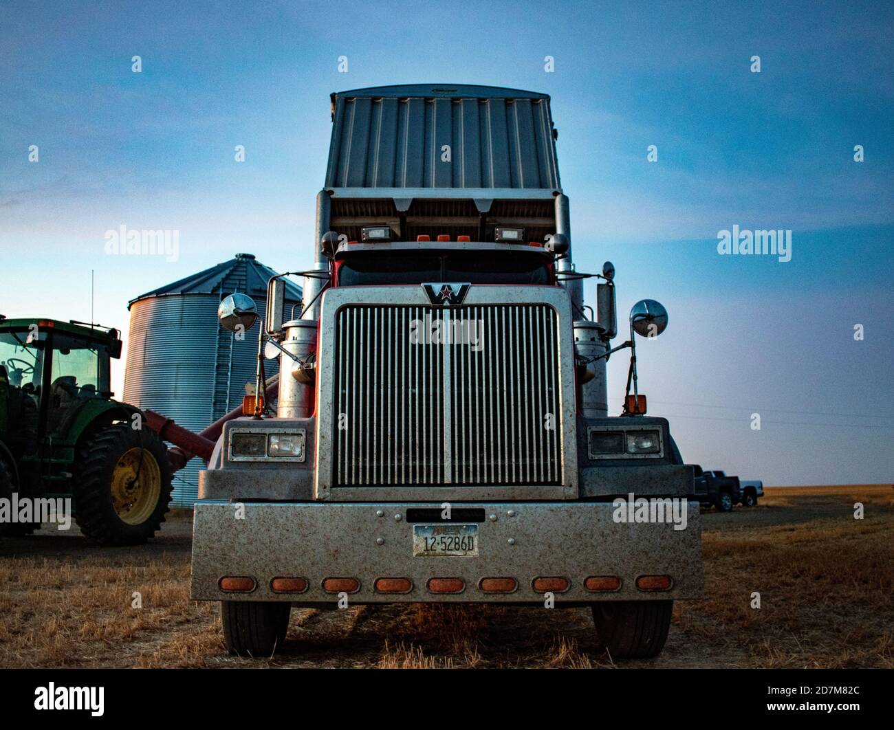 Hoist lift grain truck unloads into bin storage Stock Photo - Alamy