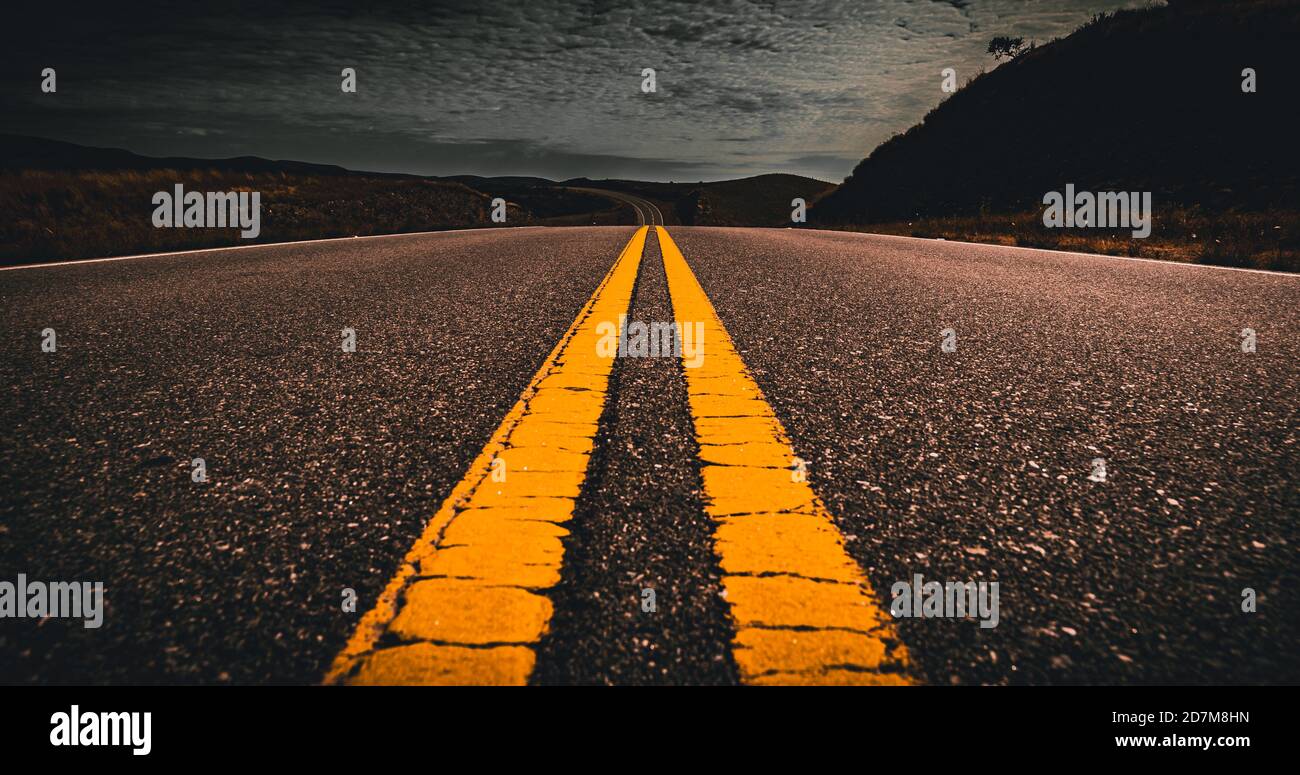 Perspective view of yellow lane lines of an old asphalt road through ...