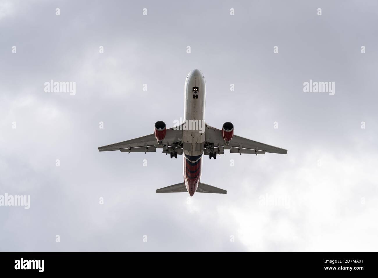 Airplane coming for landing with wheels down Stock Photo - Alamy