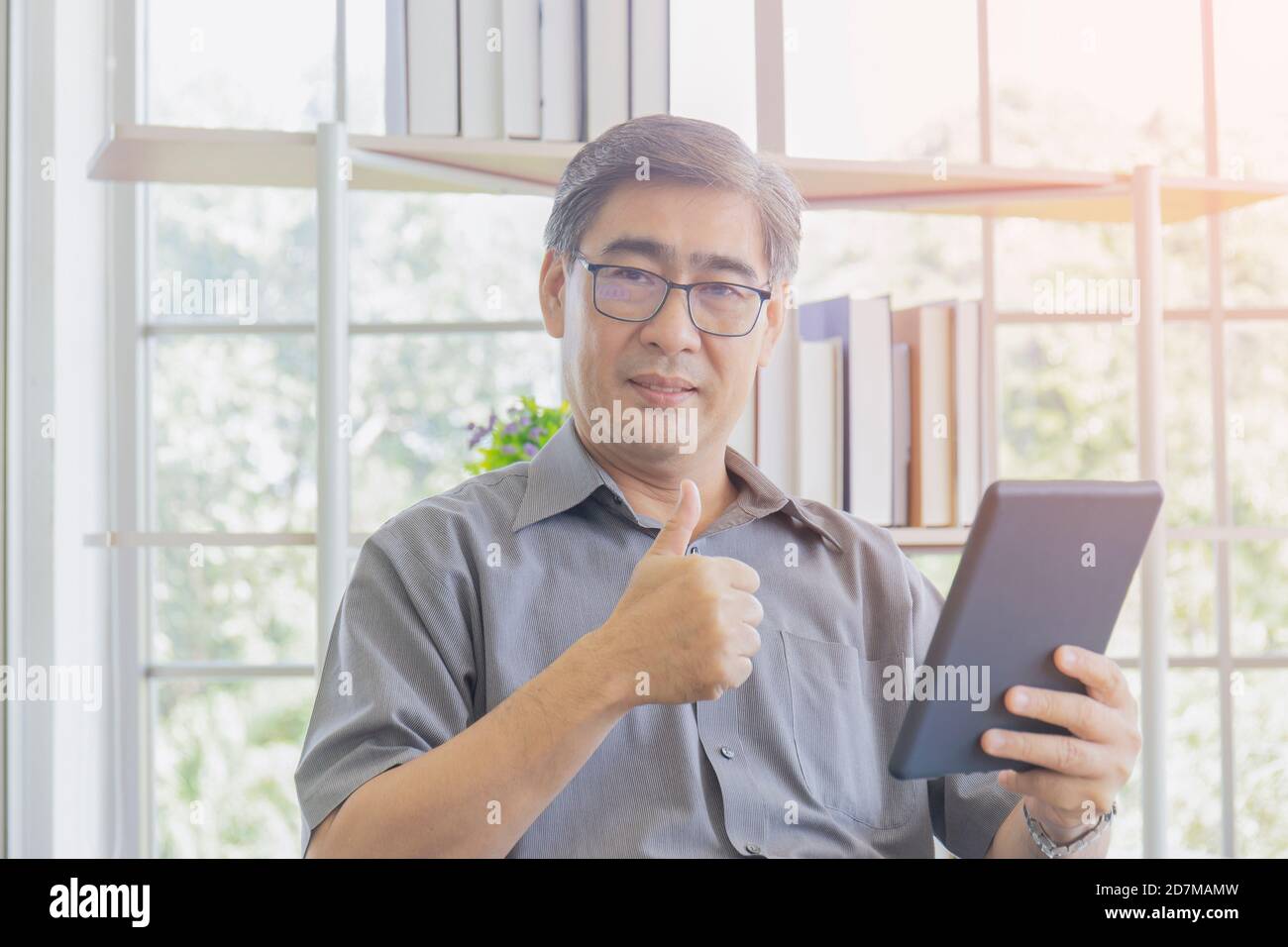An Asian Middle Aged Man Using An Ipad In His Hand Feels Great Stock