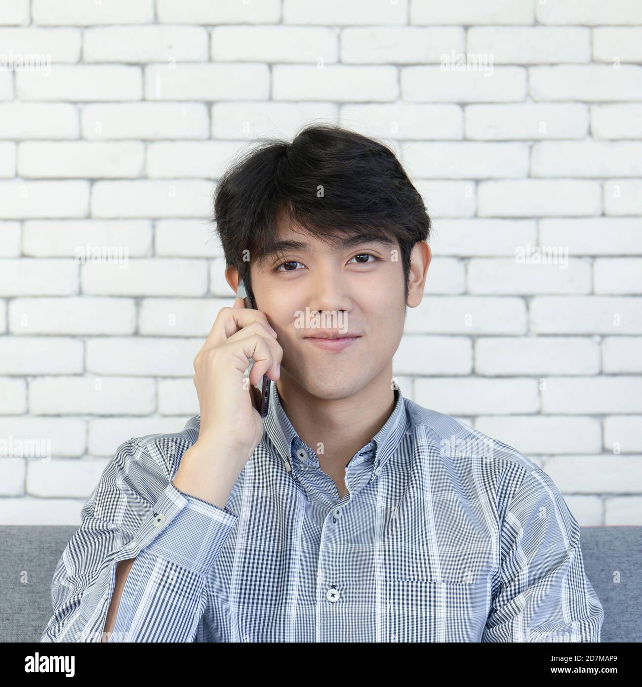 A young Asian man talking on his cell phone and smiling brightly Stock ...