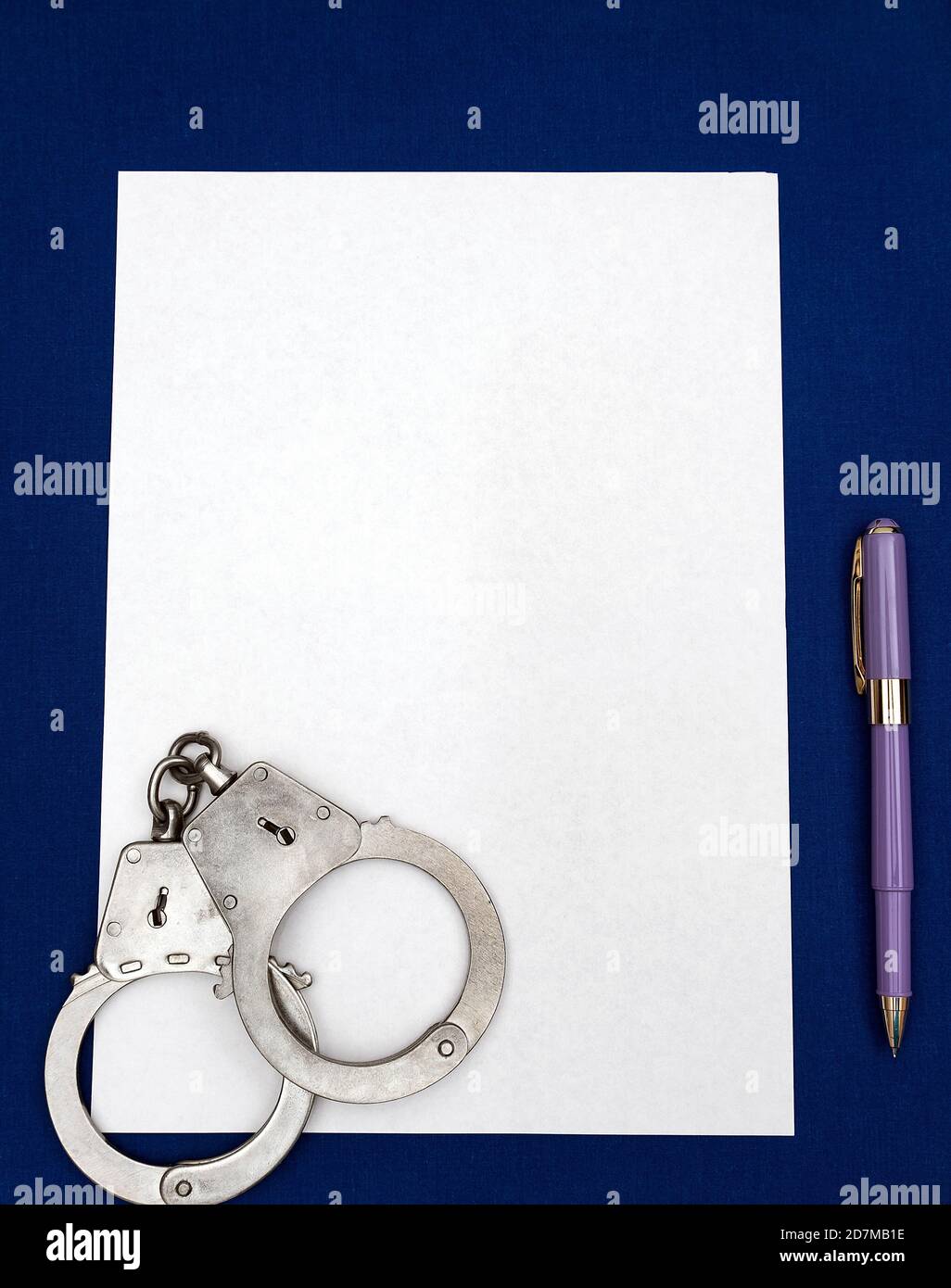 Handcuffs and Blank Paper on the Blue Fabric Background closeup Stock ...