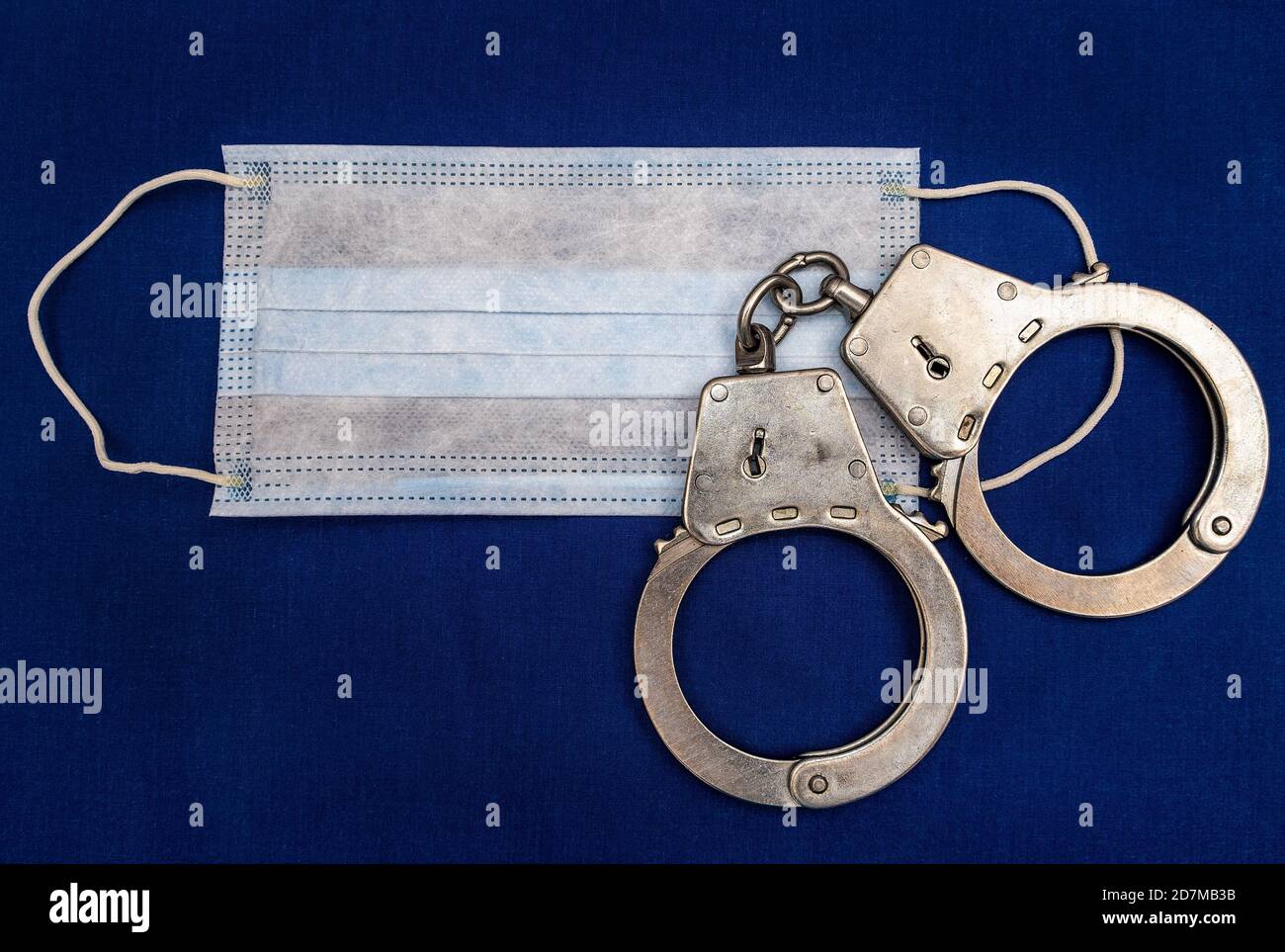Medical Flu Mask and Handcuffs on the Blue Fabric Background closeup ...