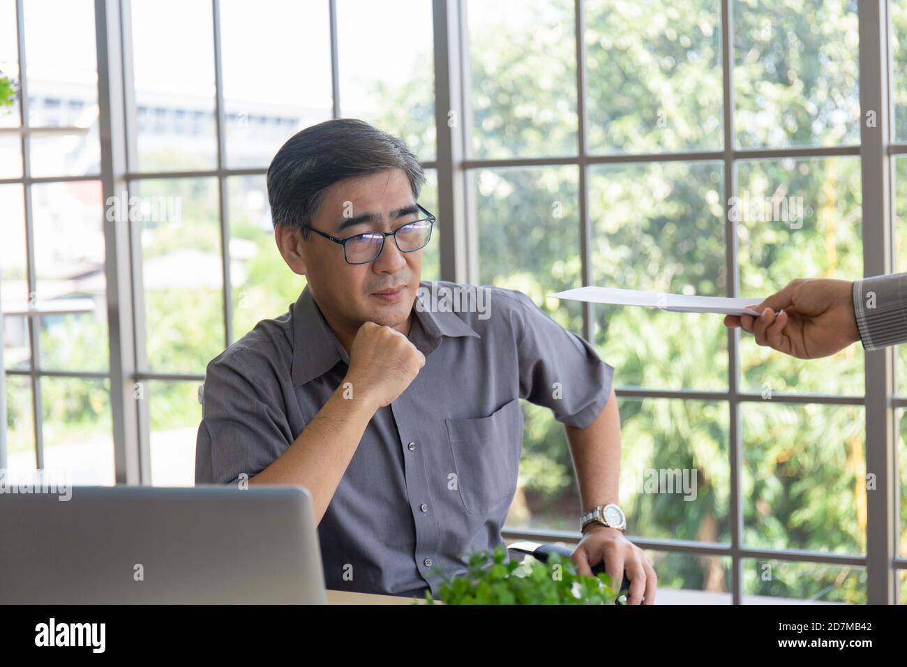 The hand that delivers documents to a grieving Asian middle-aged man ...