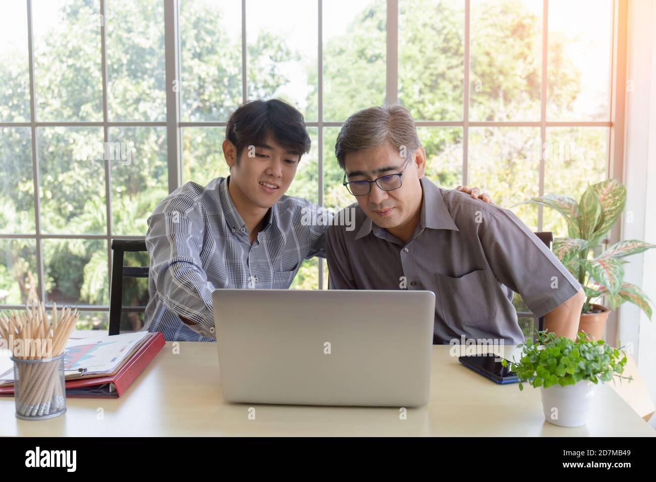 An elderly Asian man is learning how to trade online through the ...