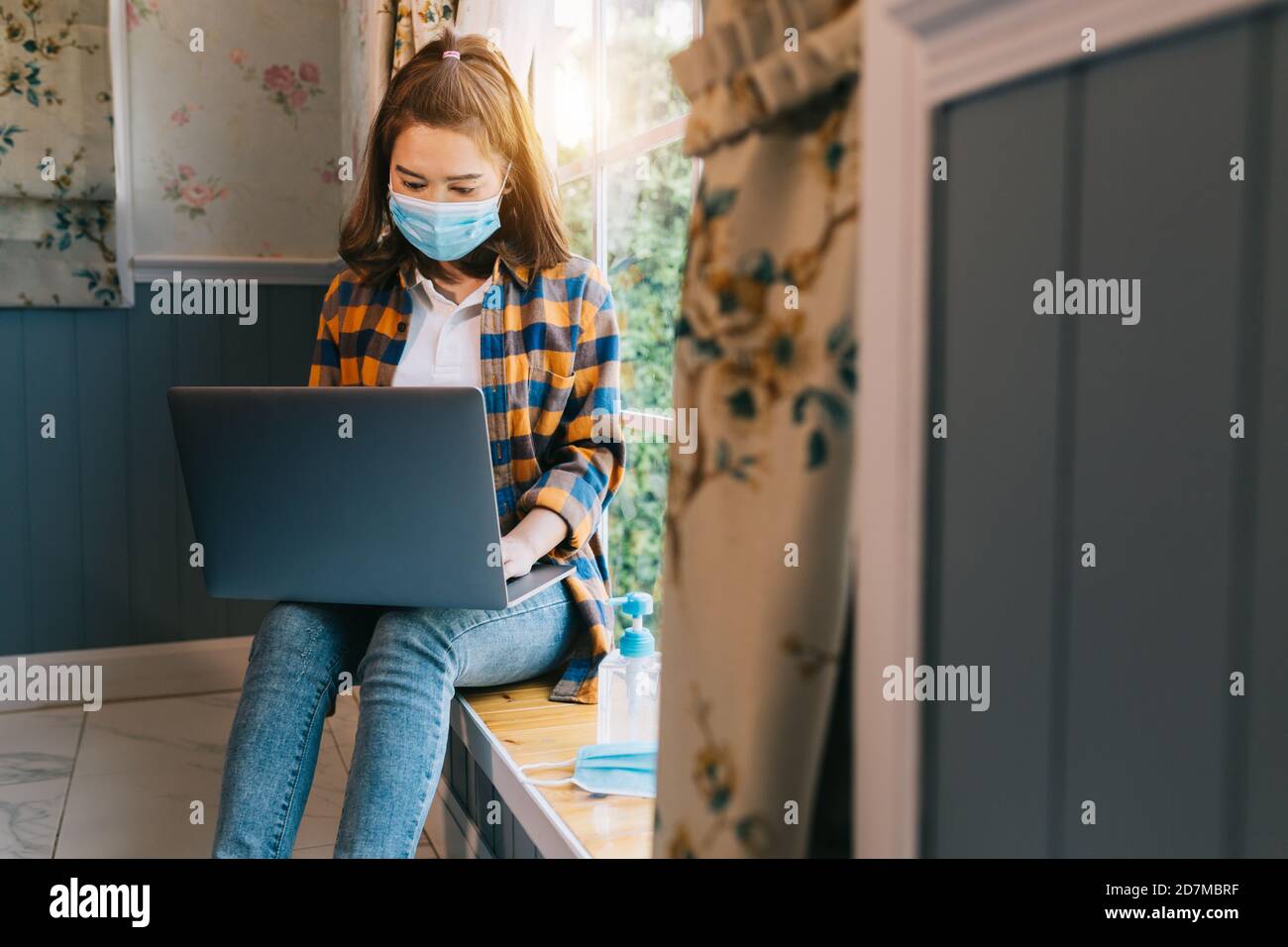 Asian female freelancer wear a mask working on project making internet ...