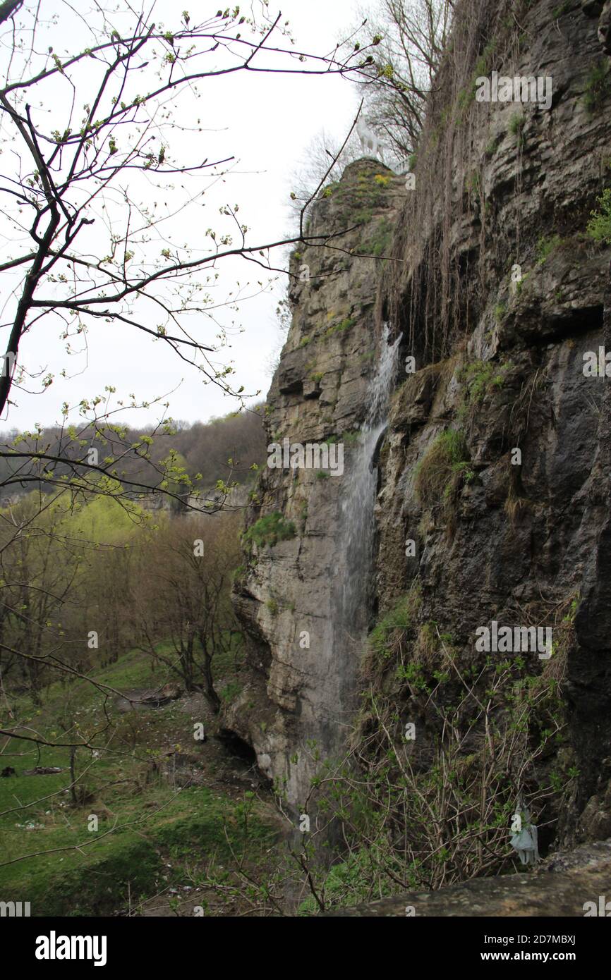 a small waterfall from the wall and cliff Stock Photo - Alamy