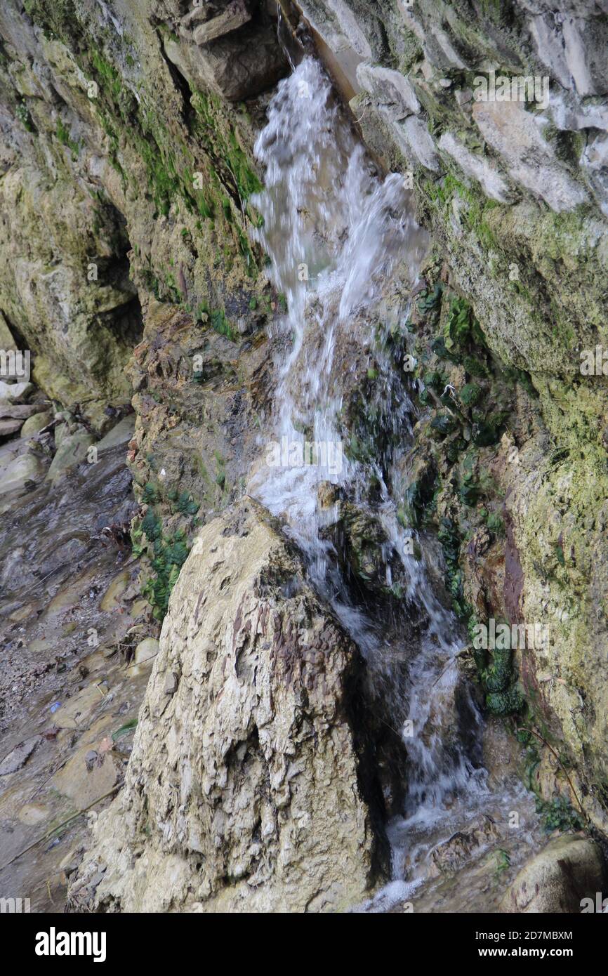 a small waterfall from the wall and cliff Stock Photo - Alamy