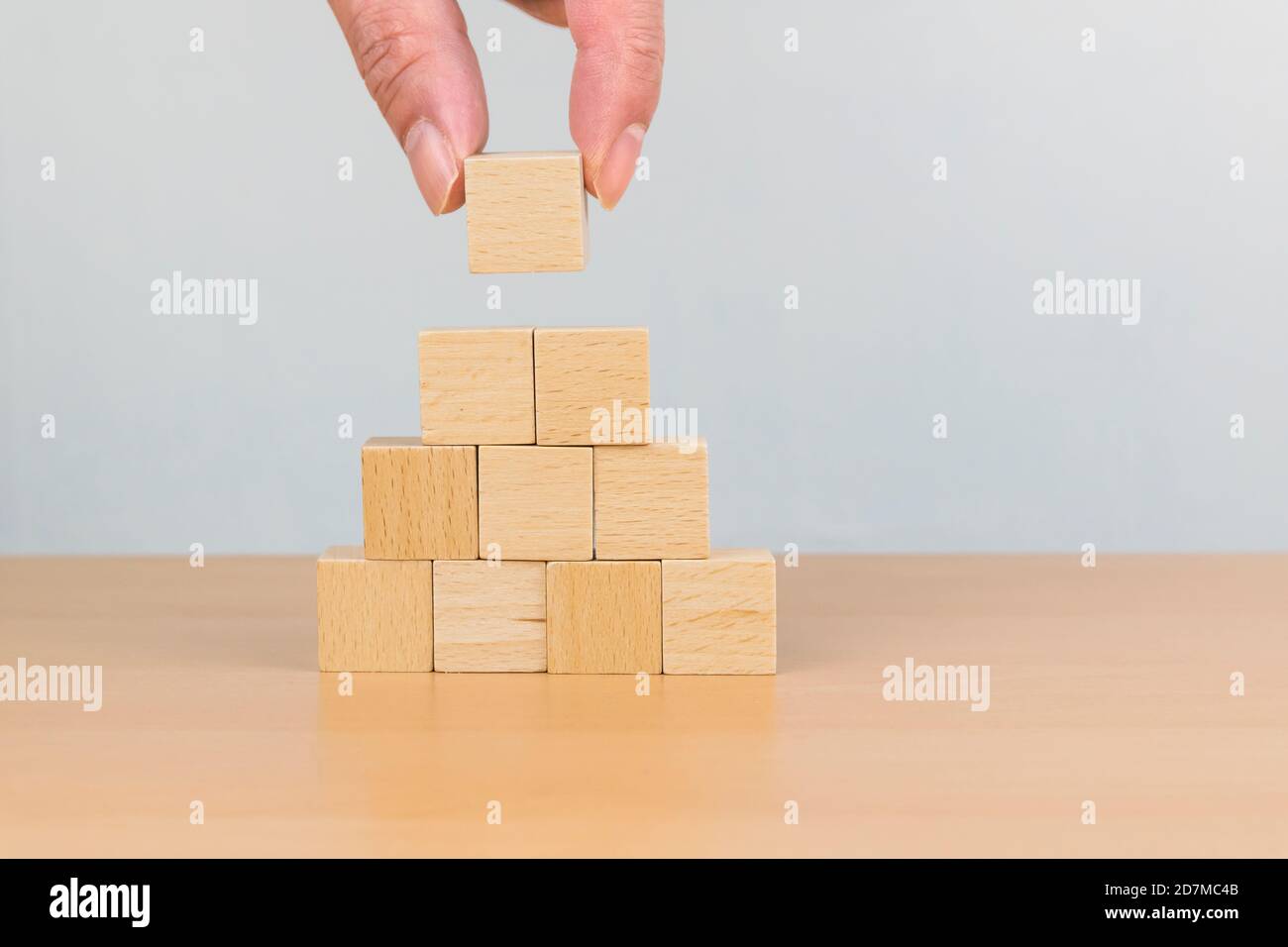 Hand arranging wood block stacking as step stair. Ladder career path ...
