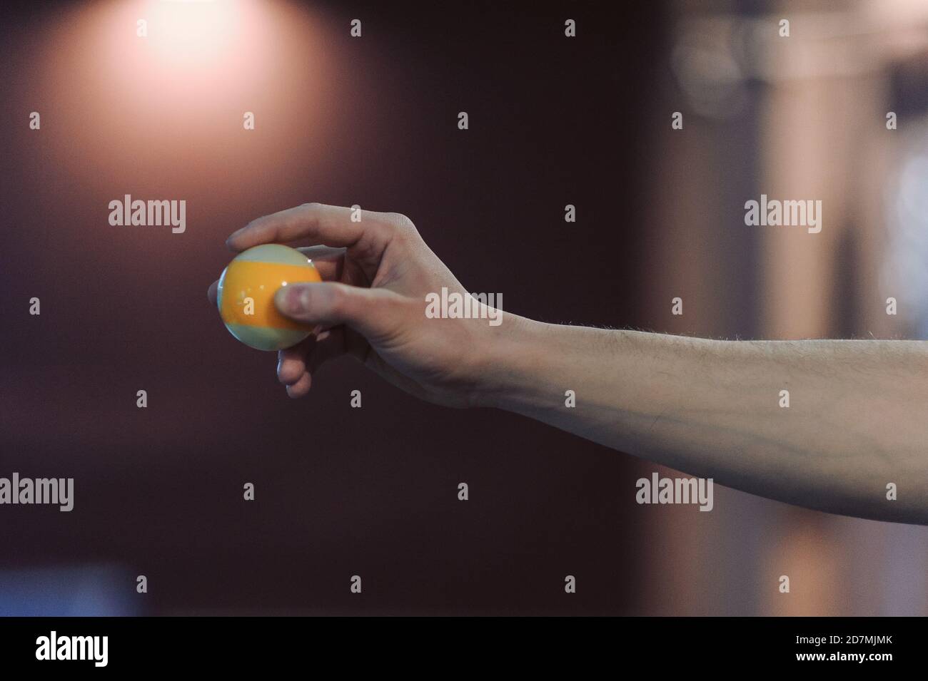 Hand holding a billiard ball in the air Stock Photo - Alamy