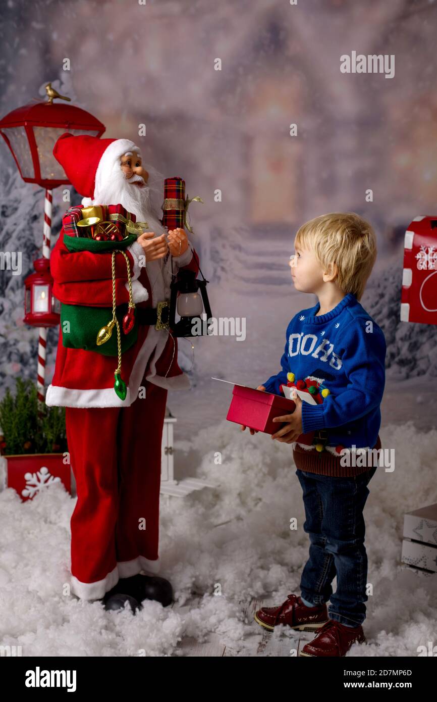 Little child, toddler boy, sending letter to santa in christmas mailbox ...