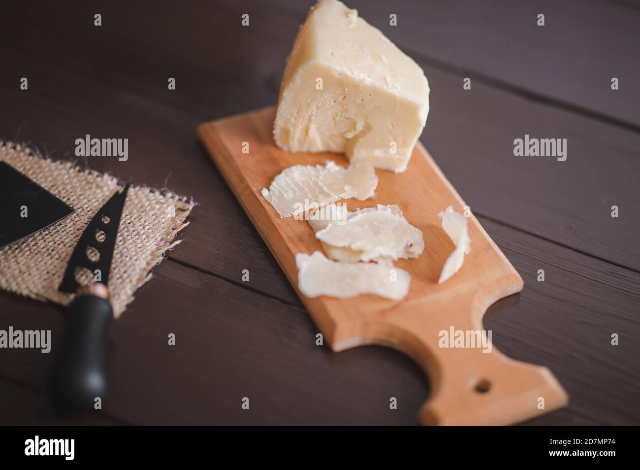Composed cloesup detail view of aged cheddar cheese with cheese knife ...