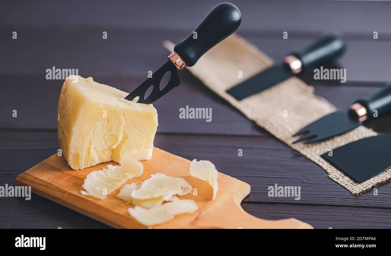 Composed cloesup detail view of aged cheddar cheese with cheese knife ...