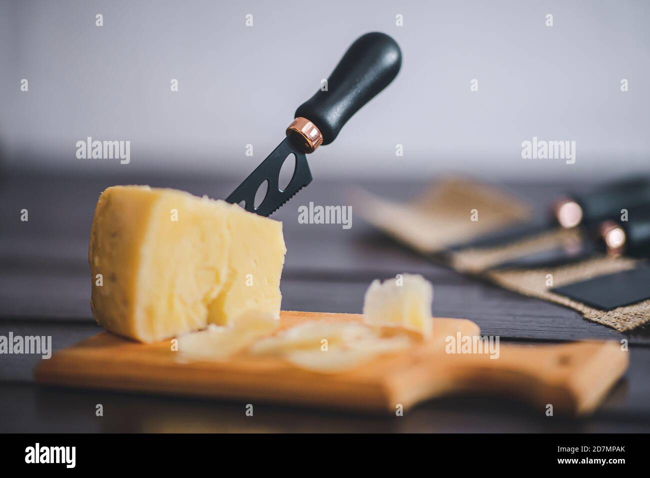 Composed cloesup detail view of aged cheddar cheese with cheese knife ...