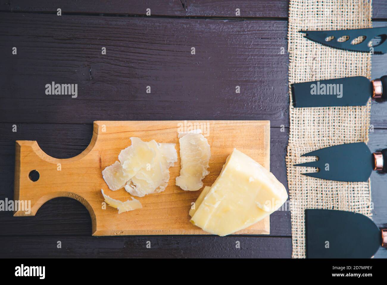 Composed Flat lay detail view of aged cheddar cheese with cheese knife ...