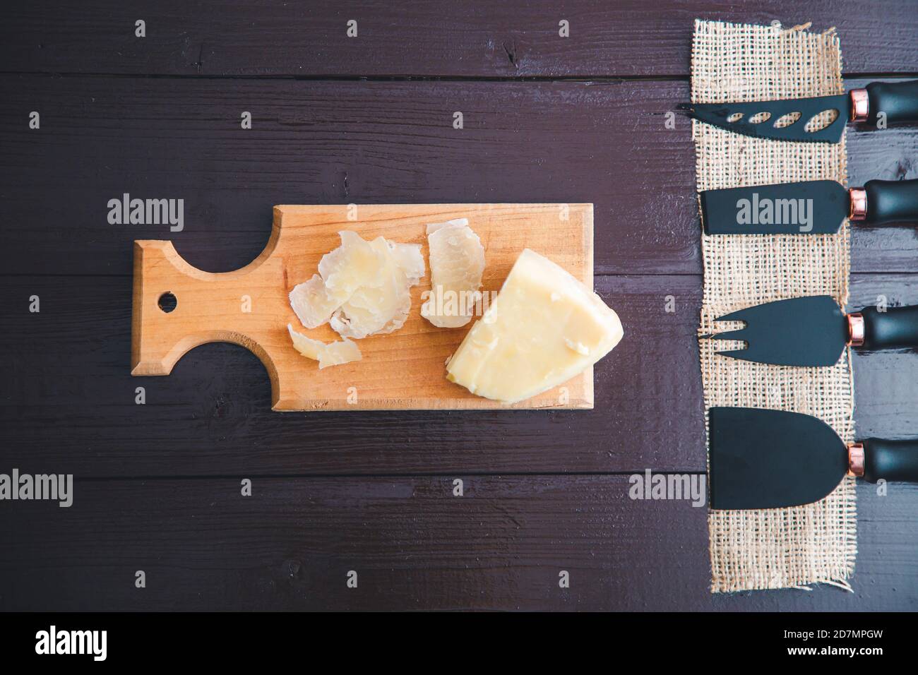Composed Flat lay detail view of aged cheddar cheese with cheese knife ...