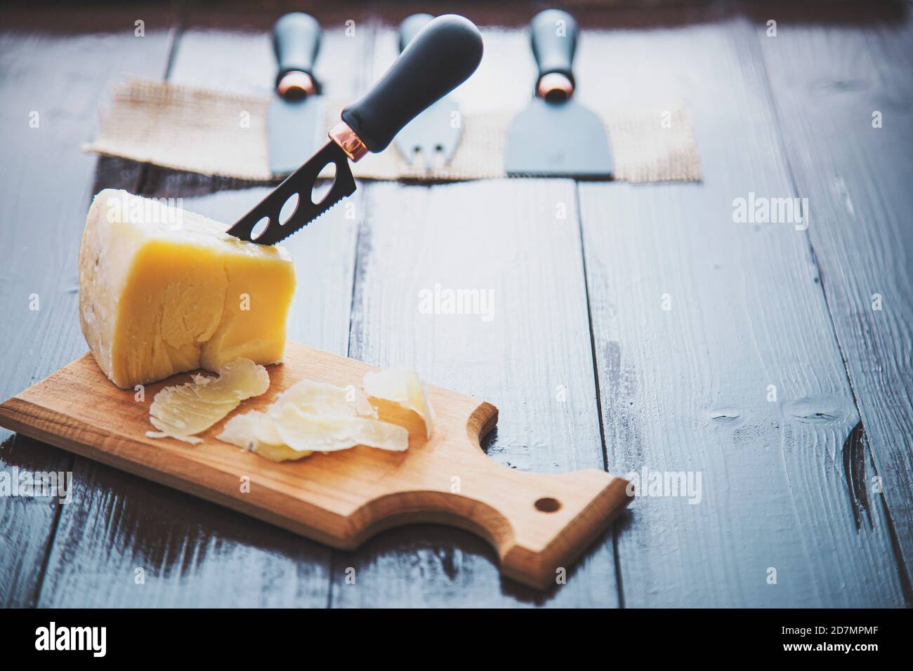 Composed cloesup detail view of aged cheddar cheese with cheese knife ...