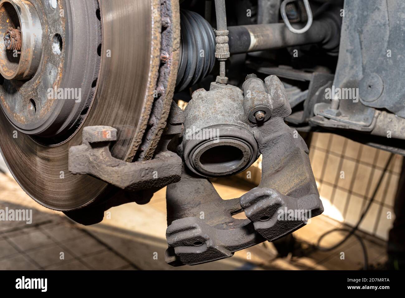 Disassembled front brake caliper on the car, which is on the car jack ...