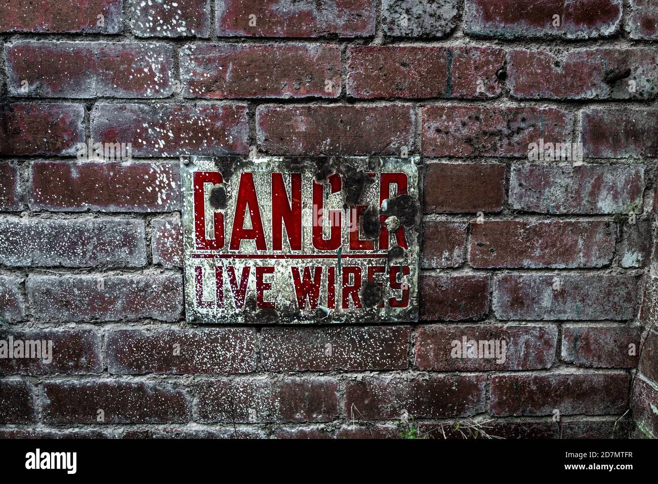 Warning sign "Danger Live Wires" mounted onto a brick wall outside a ...
