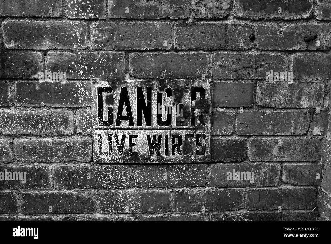 Warning sign "Danger Live Wires" mounted onto a brick wall outside a ...