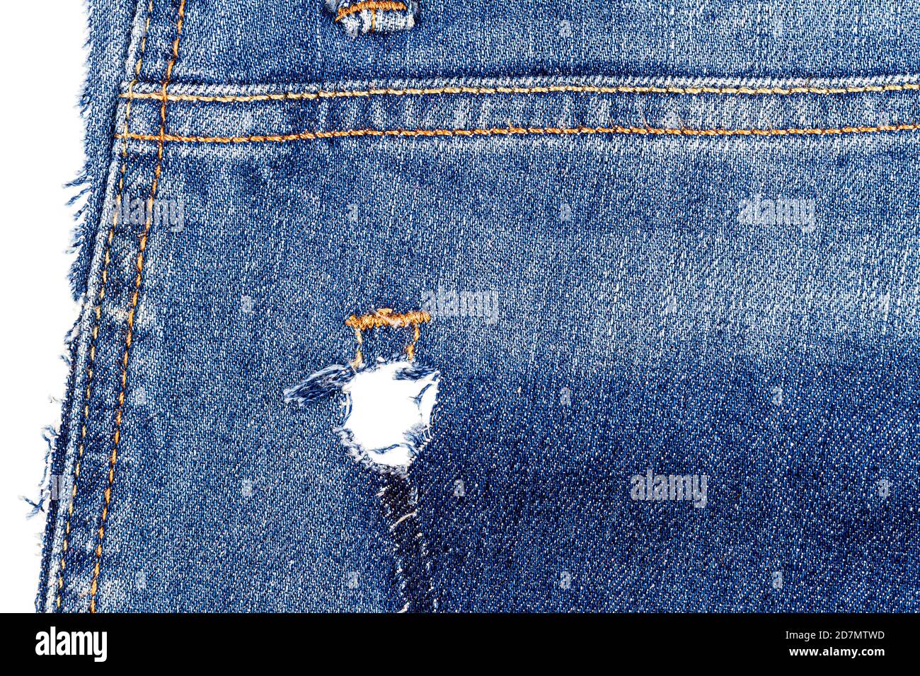 Piece of blue jeans fabric with a ripped of back pocket isolated on ...