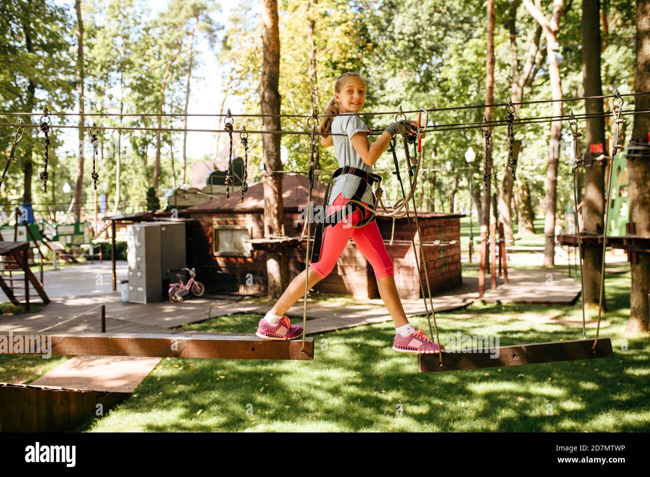 Little girl climbs in rope park Stock Photo - Alamy