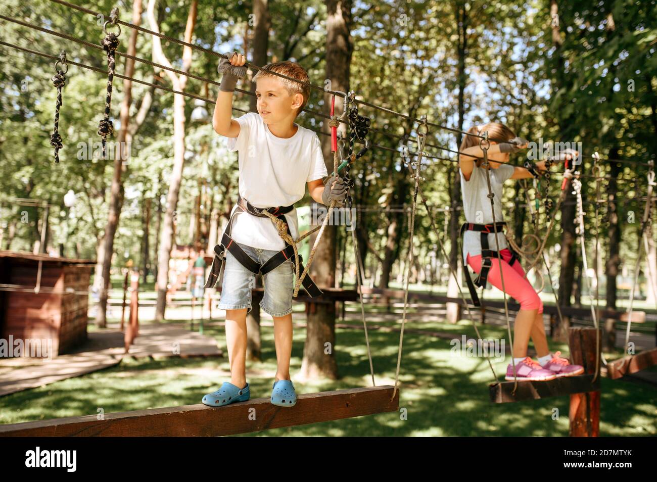 Little girl and boy climbs in rope park Stock Photo - Alamy