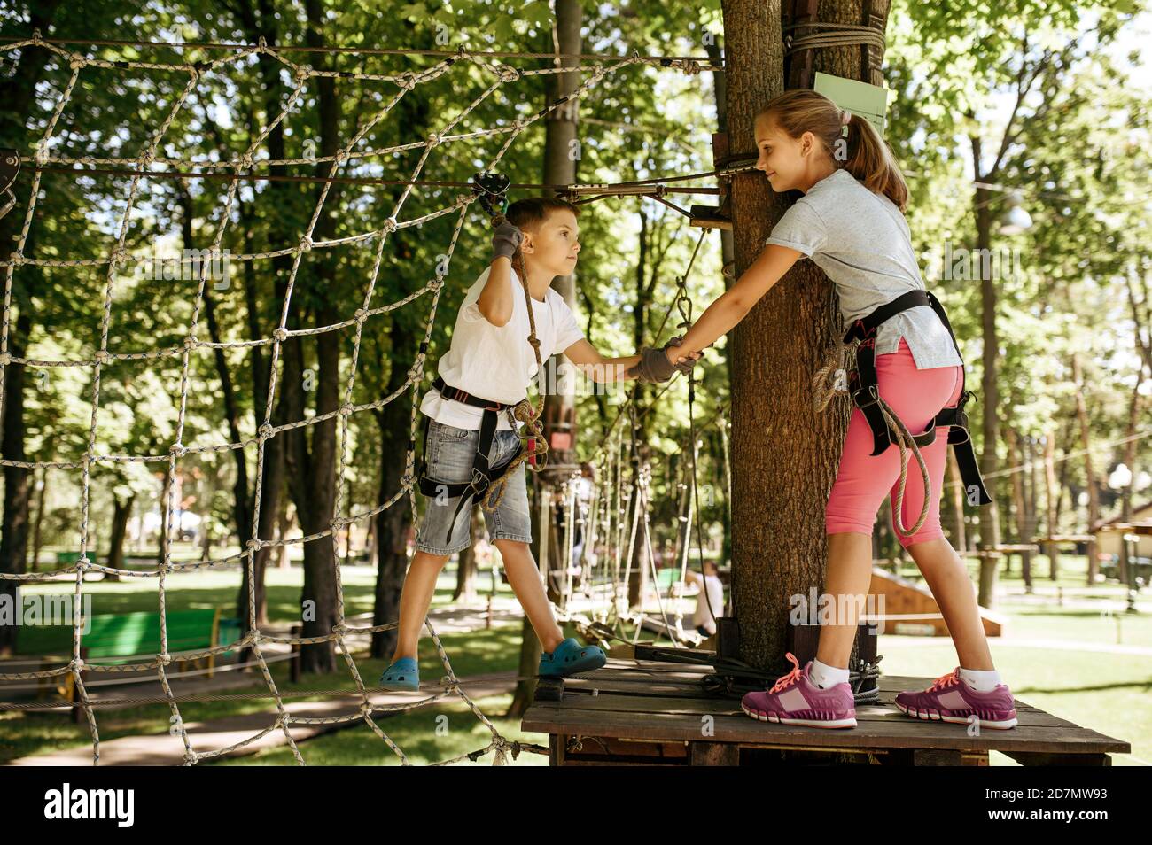 Little kids climbs on net in rope park, playground Stock Photo - Alamy