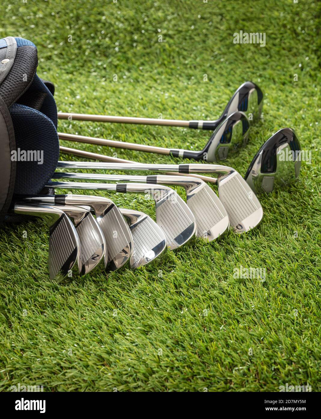 Golf sticks set in a bag on green course lawn, shiny stainless steel ...
