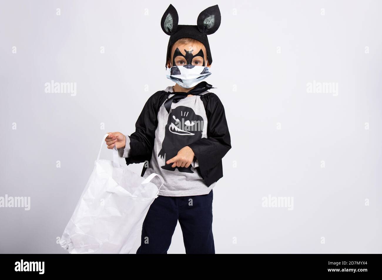 A boy dressed with a bucket of candy during the coronavirus pandemic ...