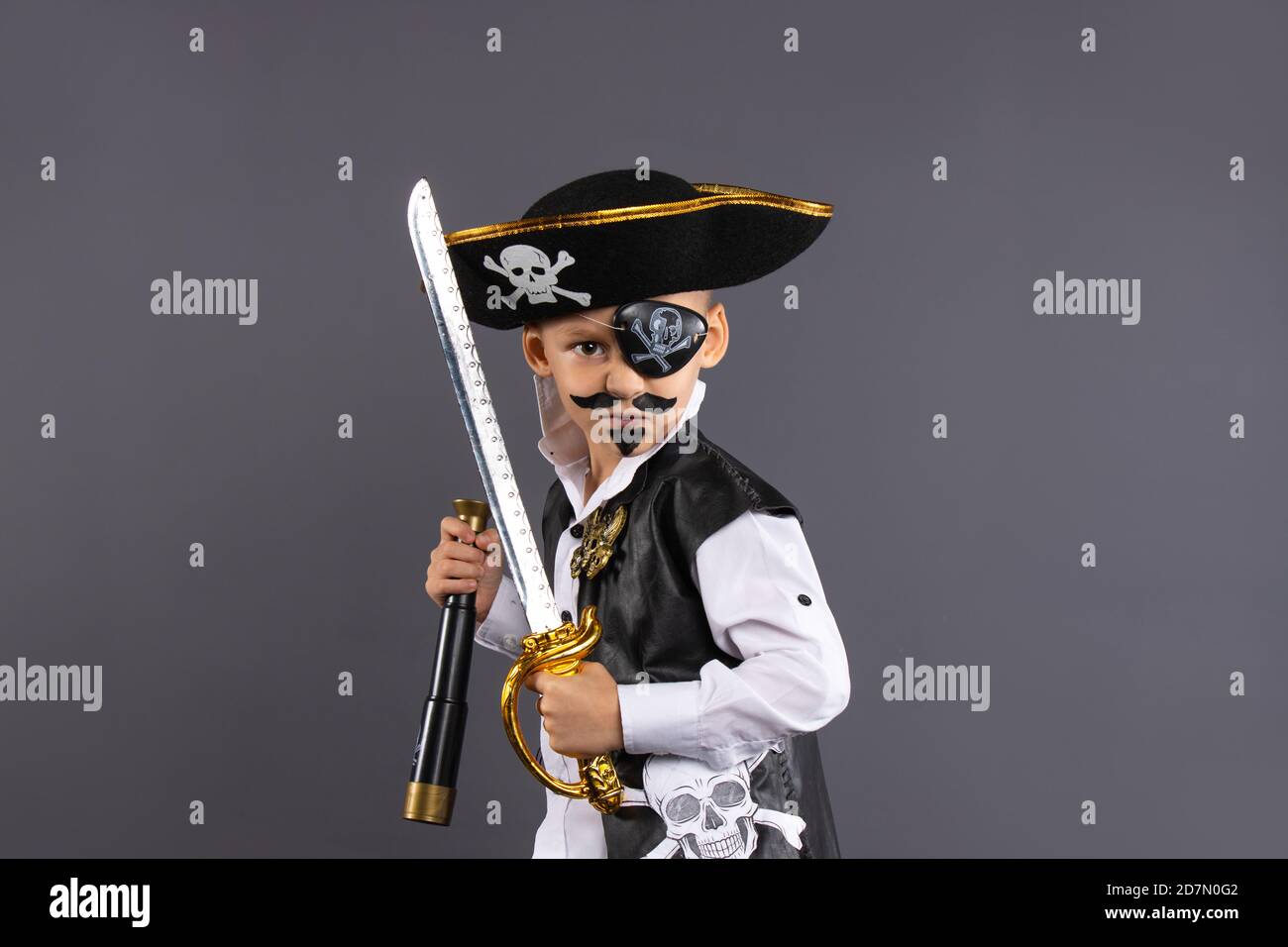 Pirate captain with painted in a defiant pose. Isolated on a gray ...