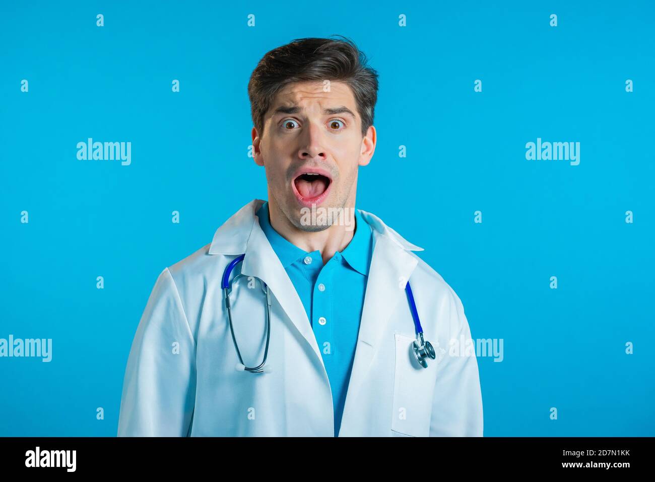 Frightened doctor man afraid of something and looks into camera with ...