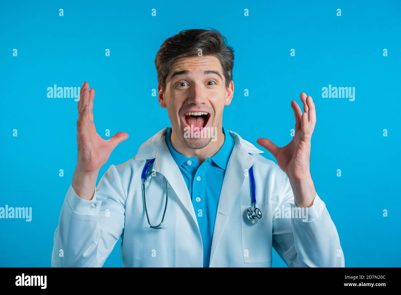Amazed doctor man shocked, saying WOW. Handsome doc in medical coat ...