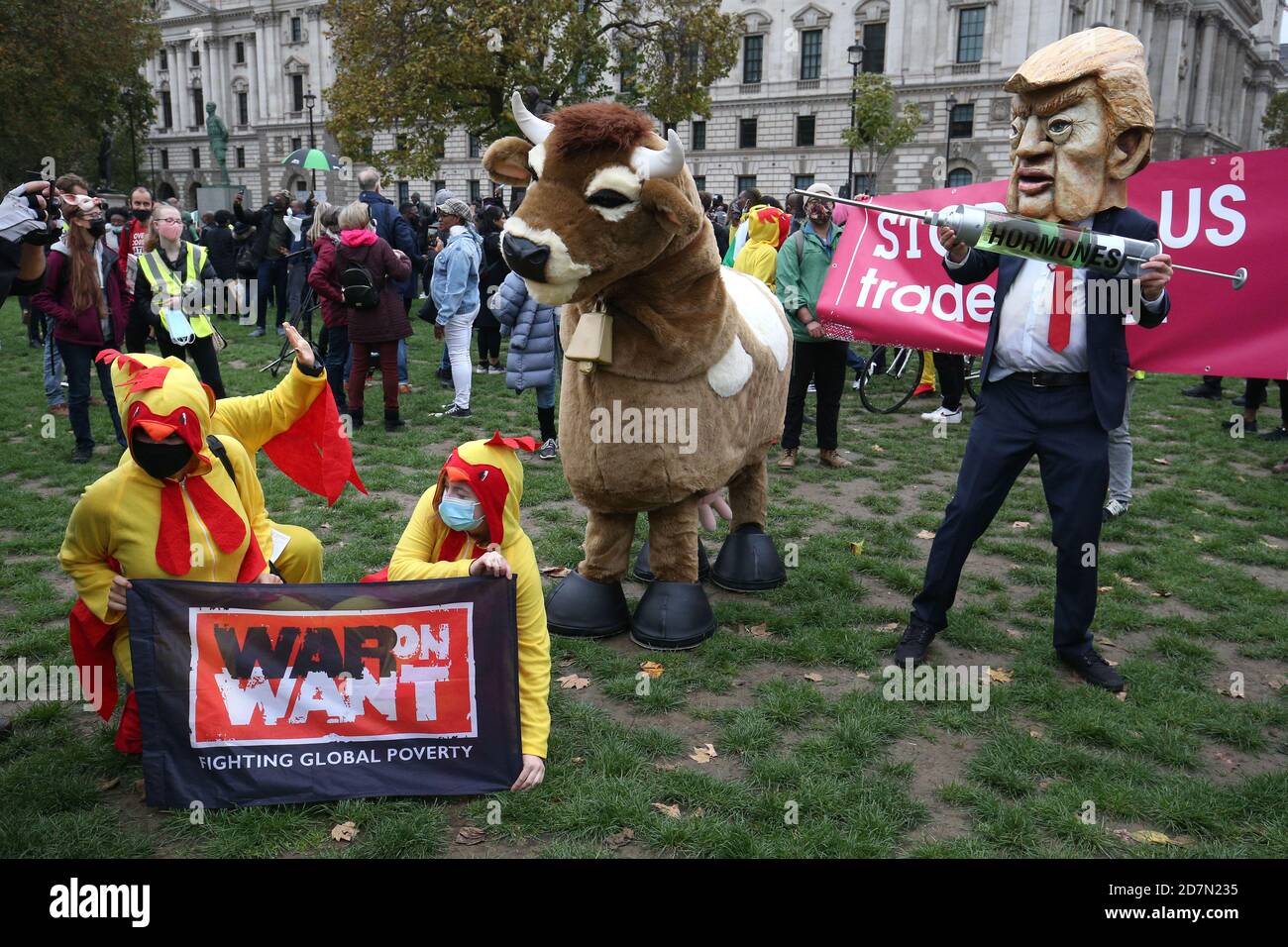 A demonstrator dressed as Donald Trump holding a syringe pretends to ...