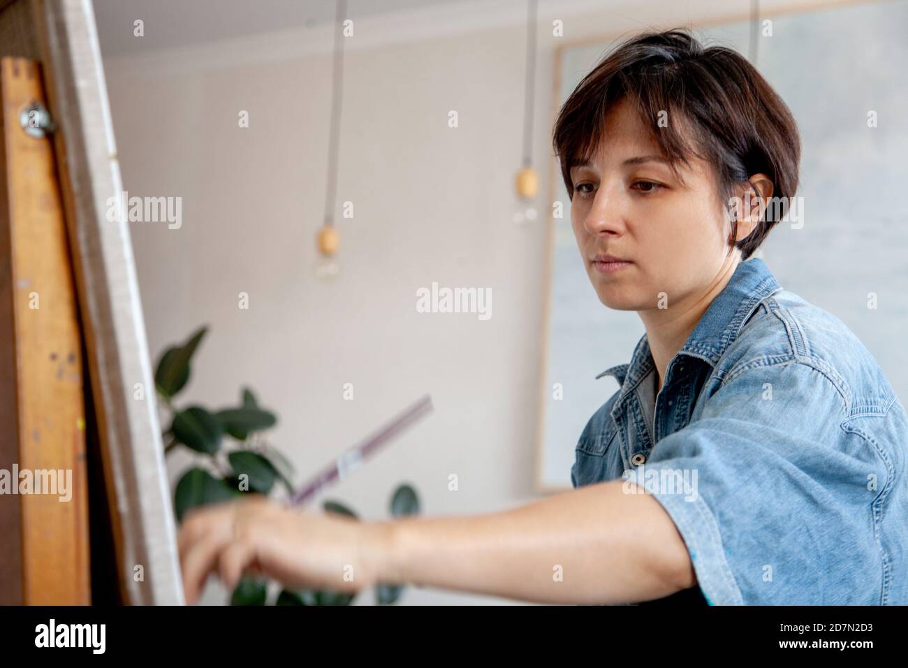 Concentrated female artist painting hi-res stock photography and images ...