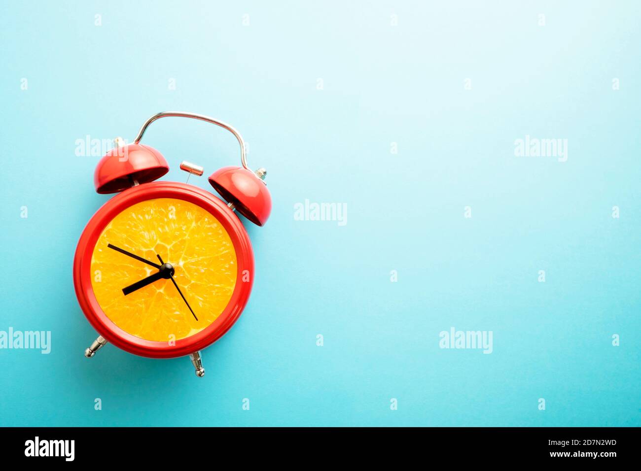Red alarm clock with a fresh orange dial Stock Photo - Alamy
