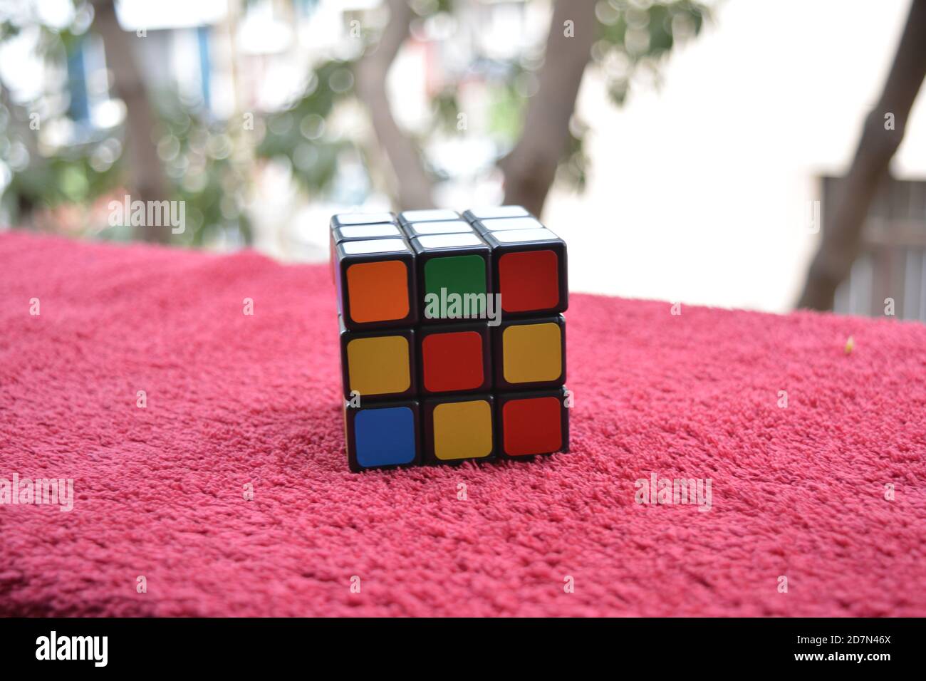 Unsolved Rubik's Cube on the red Background Stock Photo - Alamy