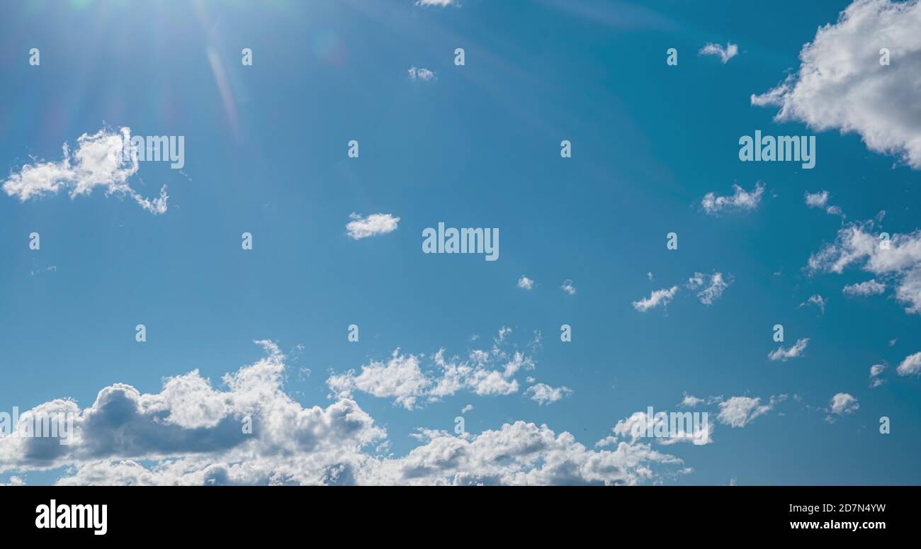 Fantastic blue sky with numerous wonderful white clouds floating fast ...