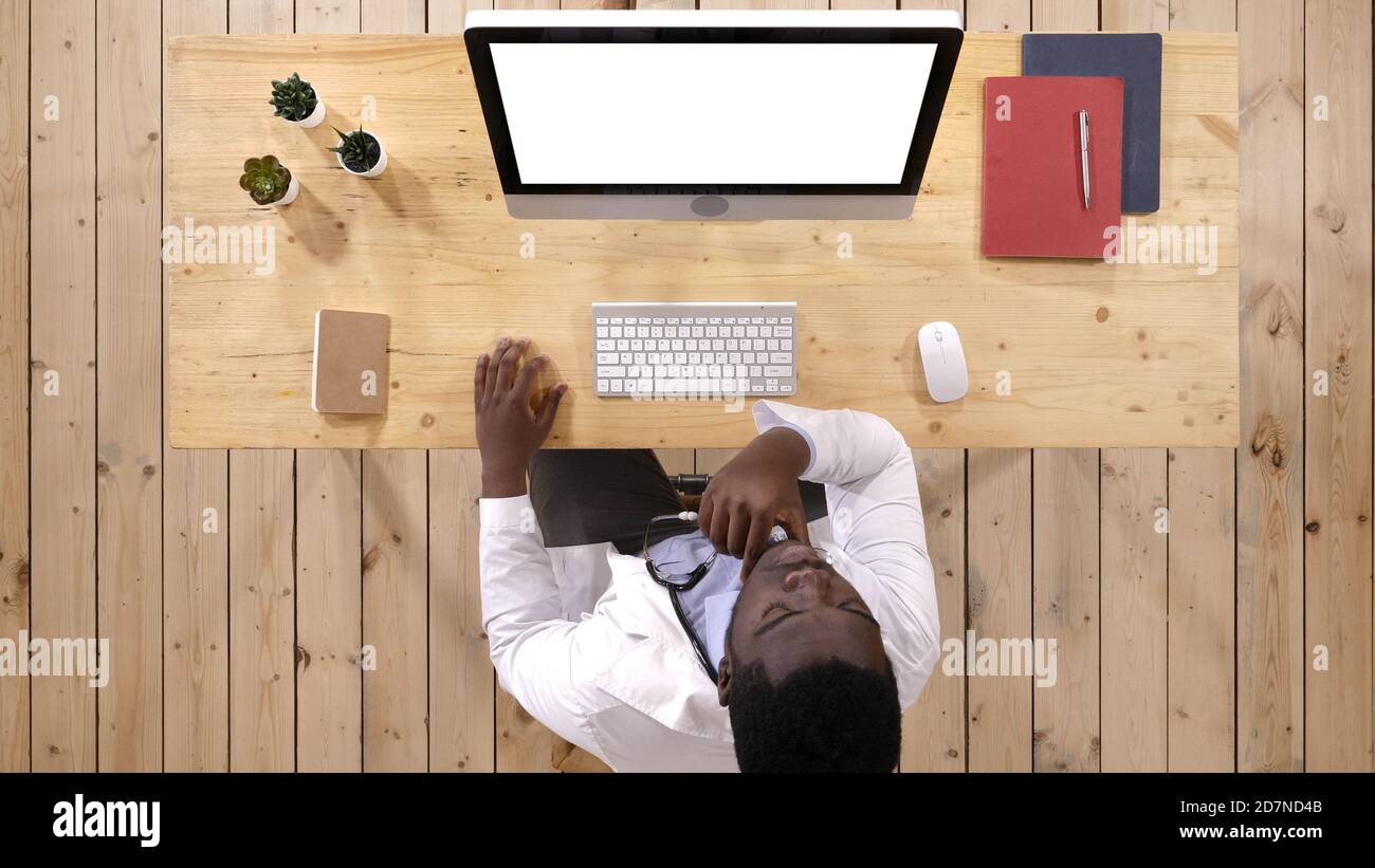 African doctor watching something on the screen of computer. Whi Stock ...