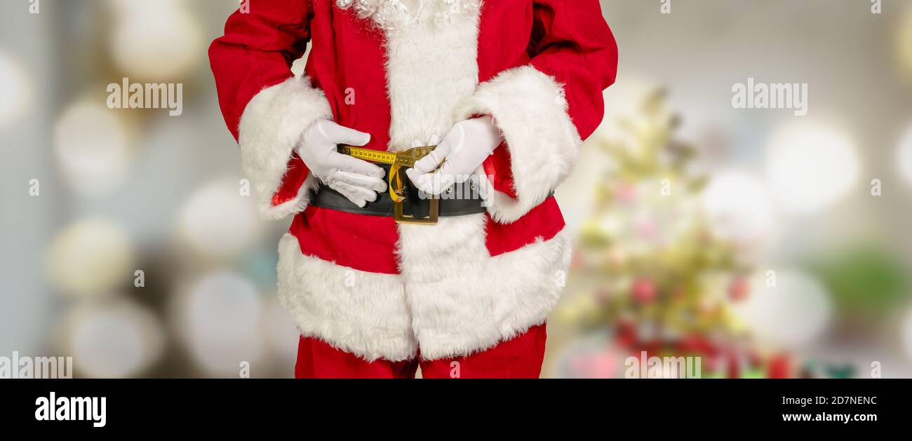 santa claus measures his stomach circumference with a tape measure ...