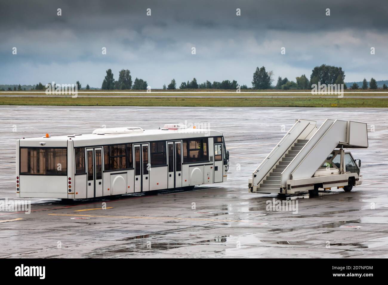 Shuttle bus and passenger boarding stairs at the airport apron in a ...
