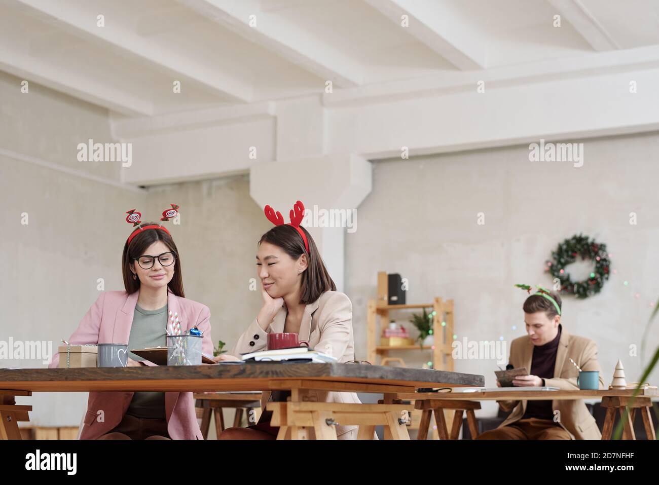 Two young successful female co-workers in elegant casualwear working ...