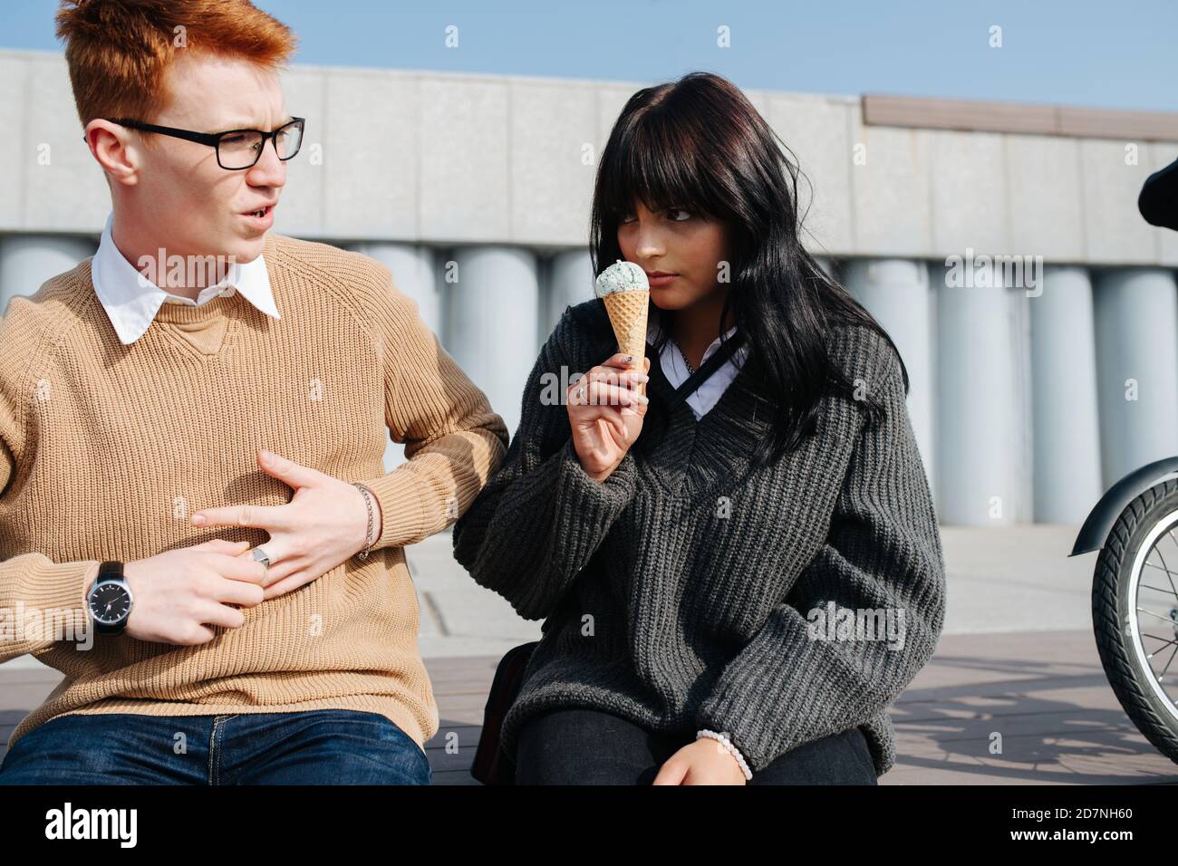 Grumpy couple sitting on the stairs outdoors, eating ice cream Stock ...