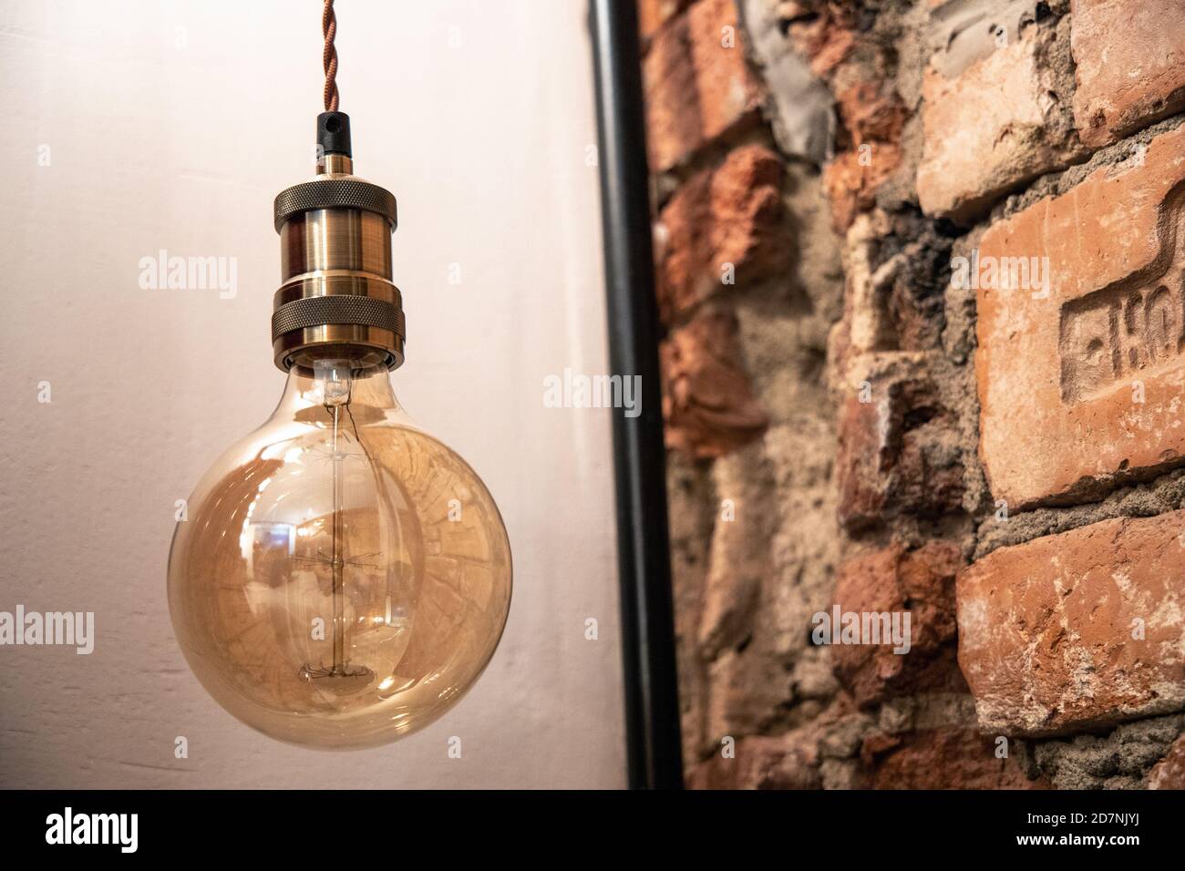 Edison lamp against a brick wall Stock Photo - Alamy