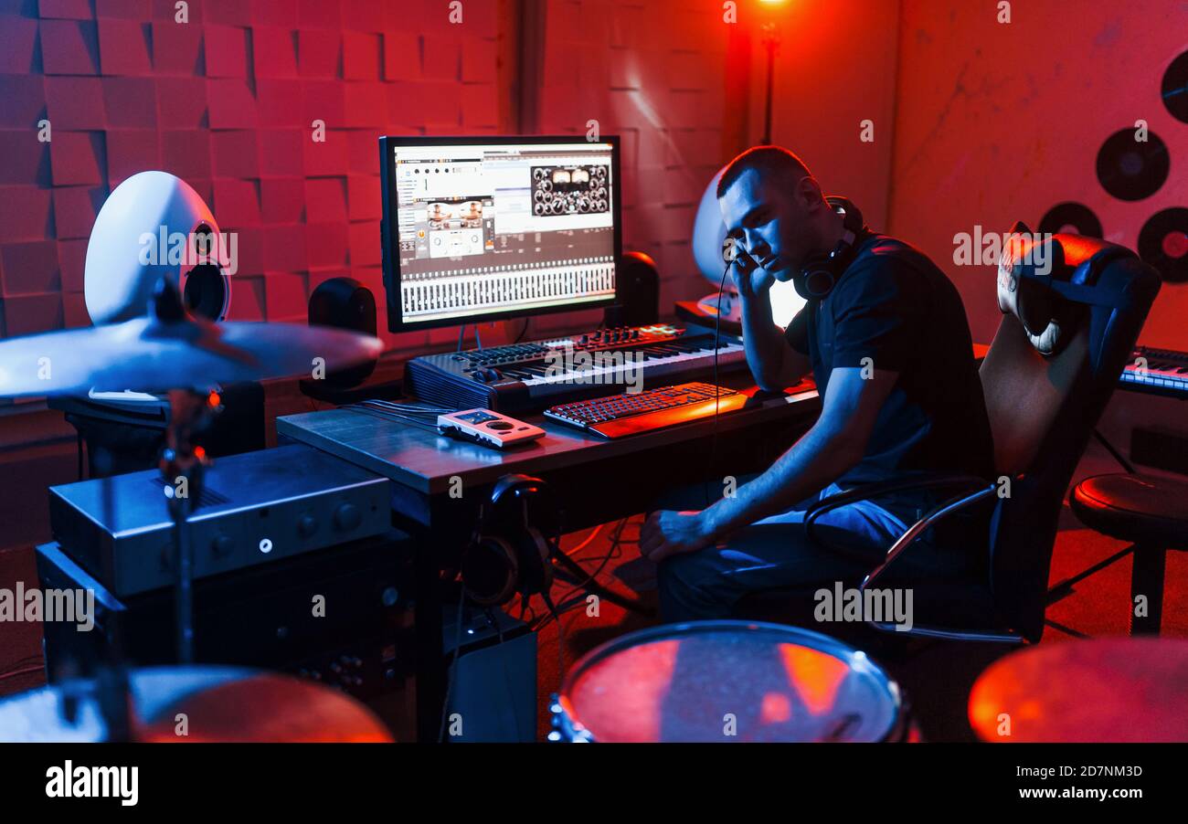 Sound engineer working and mixing music indoors in the studio near drum kit Stock Photo - Alamy